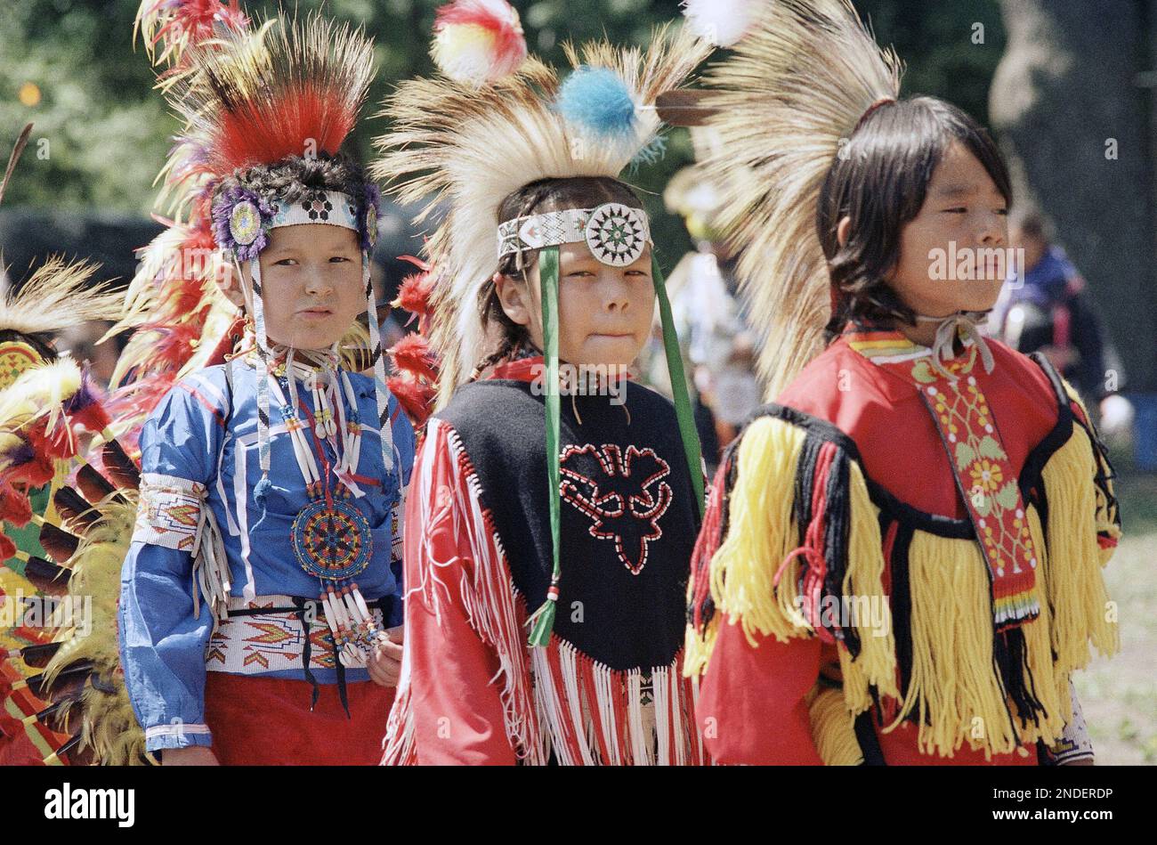 Three Indian youths, in tribal dress, await their turn to perform at ...