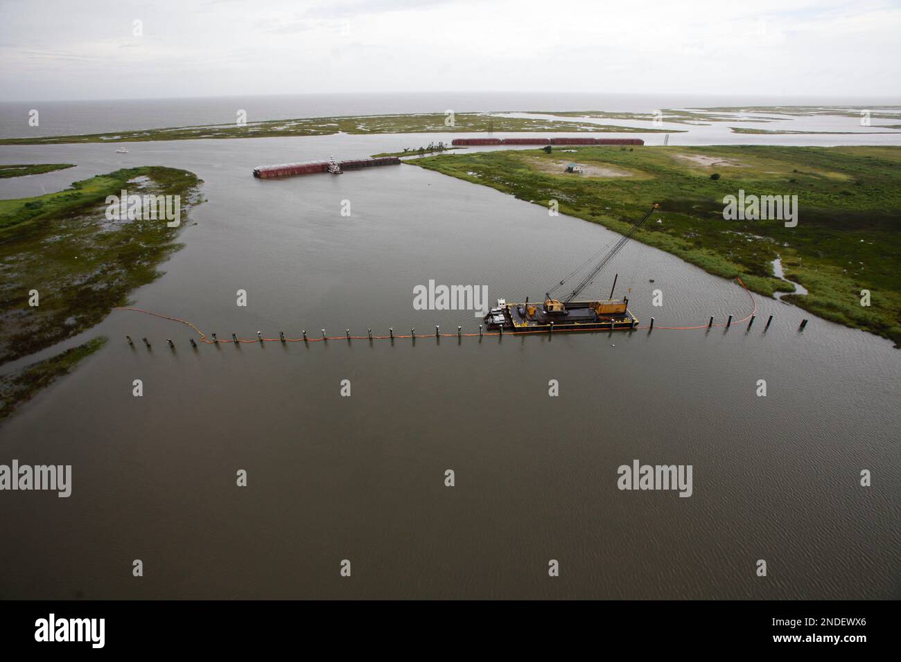Barges line up to block oil are seen from the air in The Rigolets ...