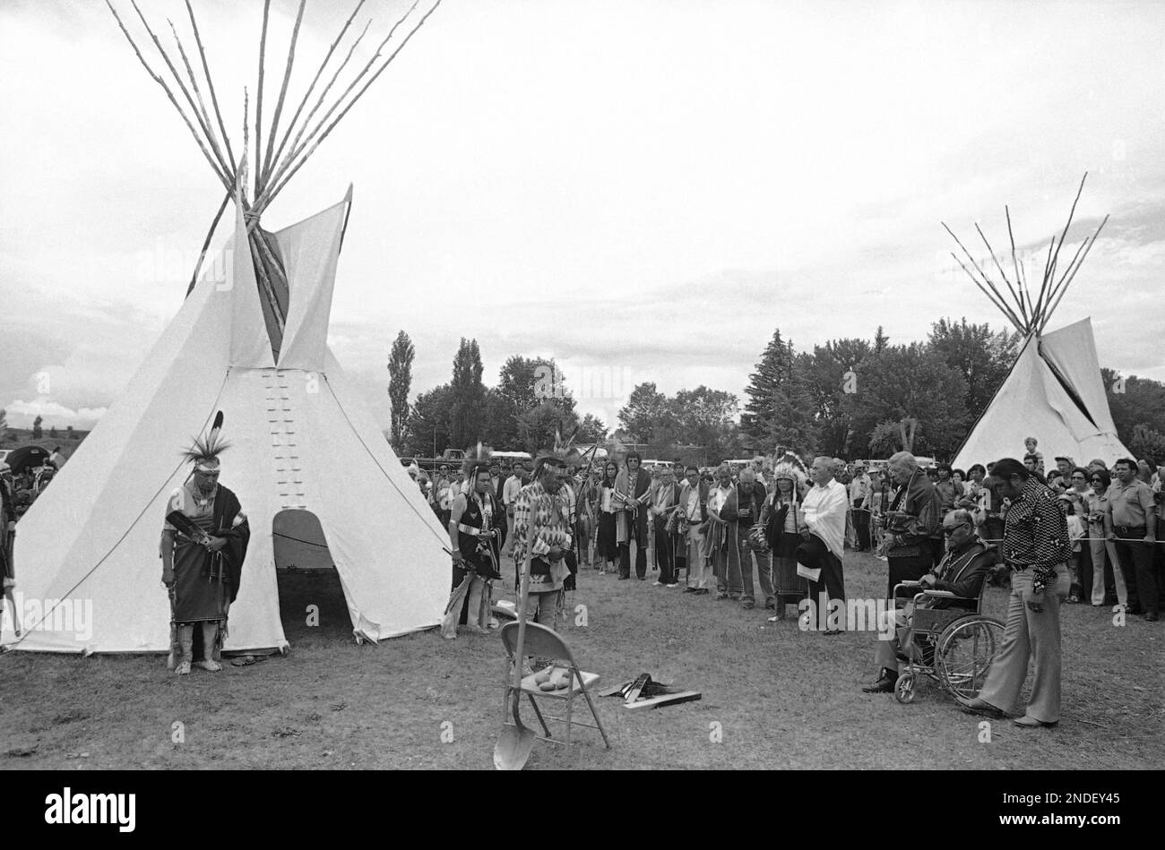 Tribal dignitaries and guests stand beside tepee during Ute-Comanche ...