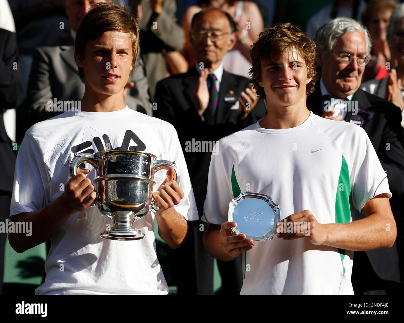 Hungary's Marton Fucsovics, left, holds his trophy after defeating ...