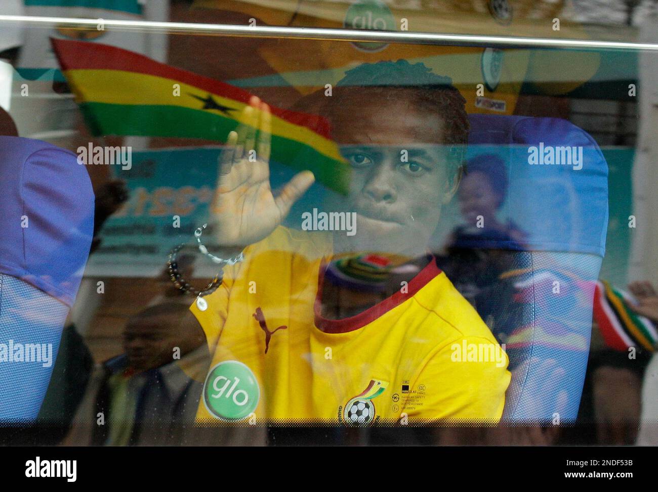 Ghana's Anthony Annan waves to fans through the reflection of a ...