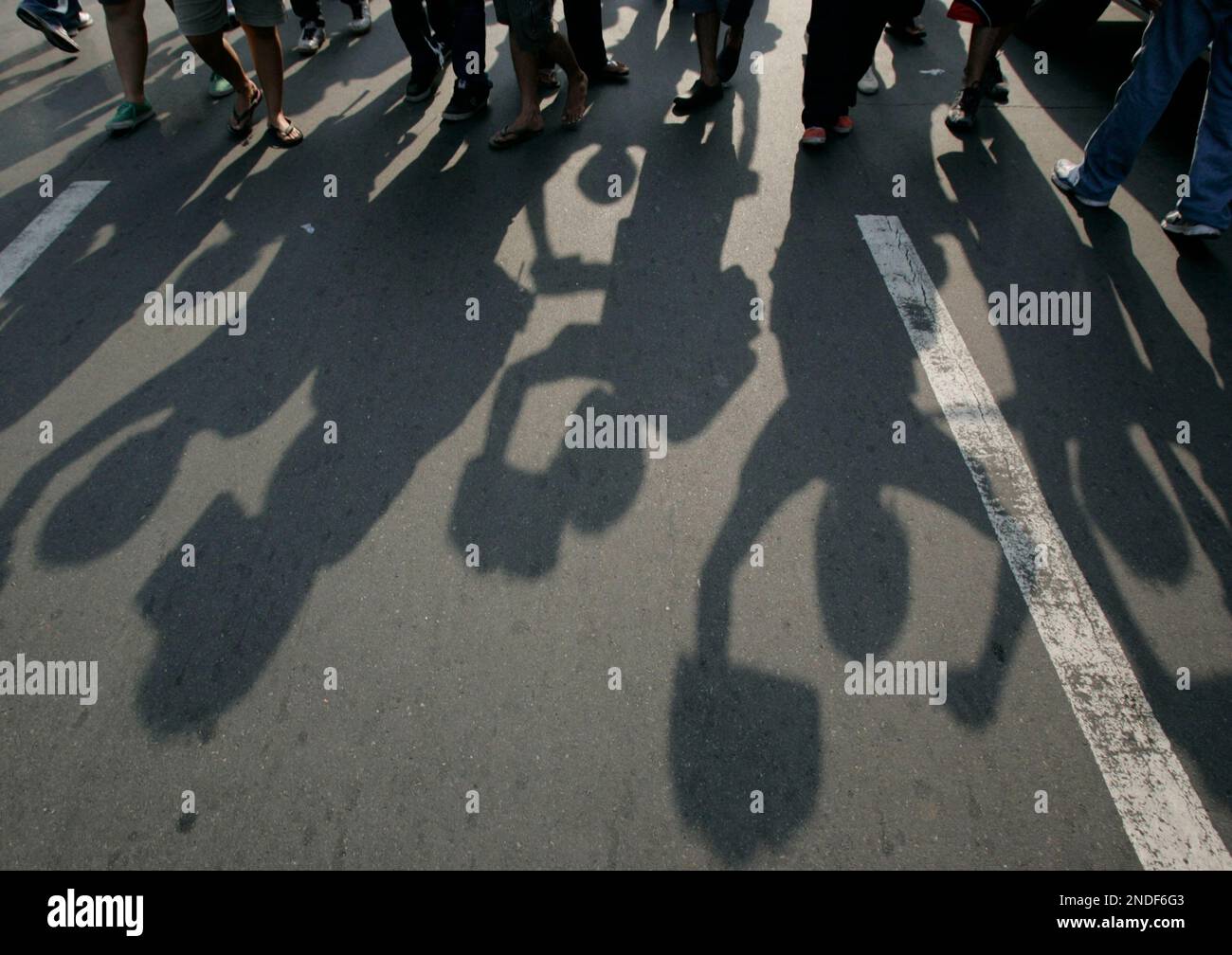 Shadows of student activists are cast on the pavement as they walk away ...