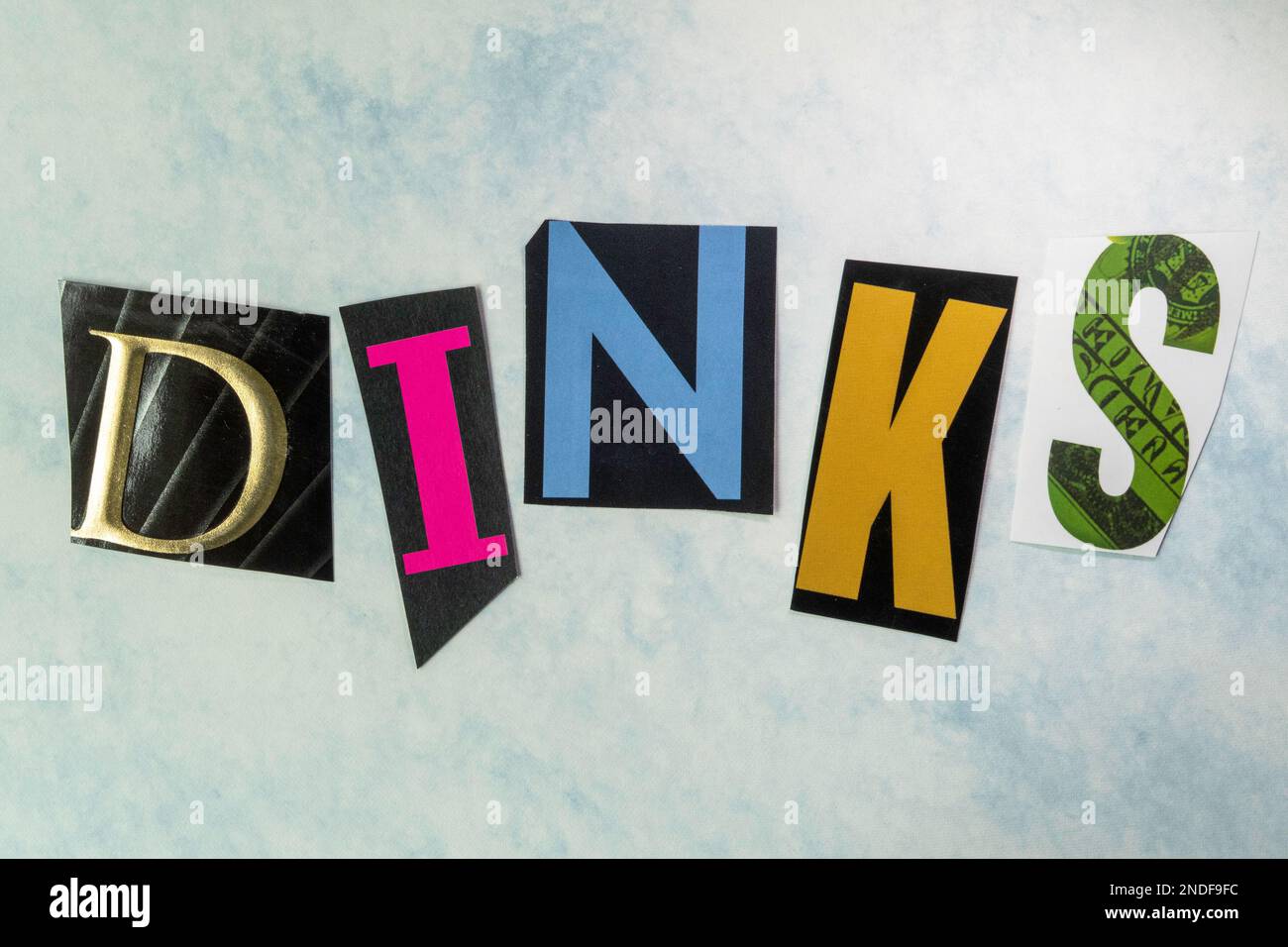 The acronym "DINKS" (Dual Income no Kids) using cut-out paper letters ...