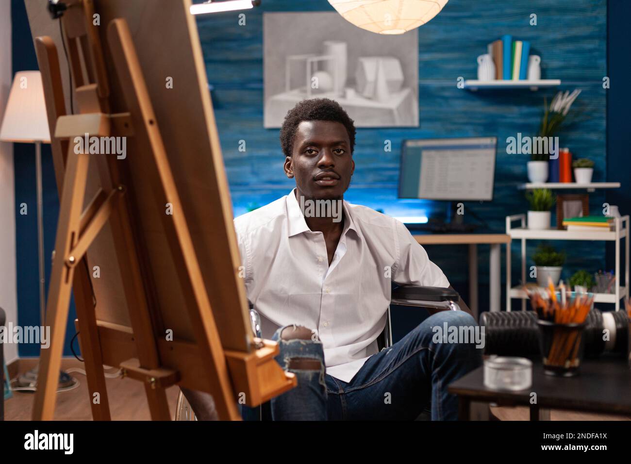 Male artist with spinal cord injury working in home art studio. African ...