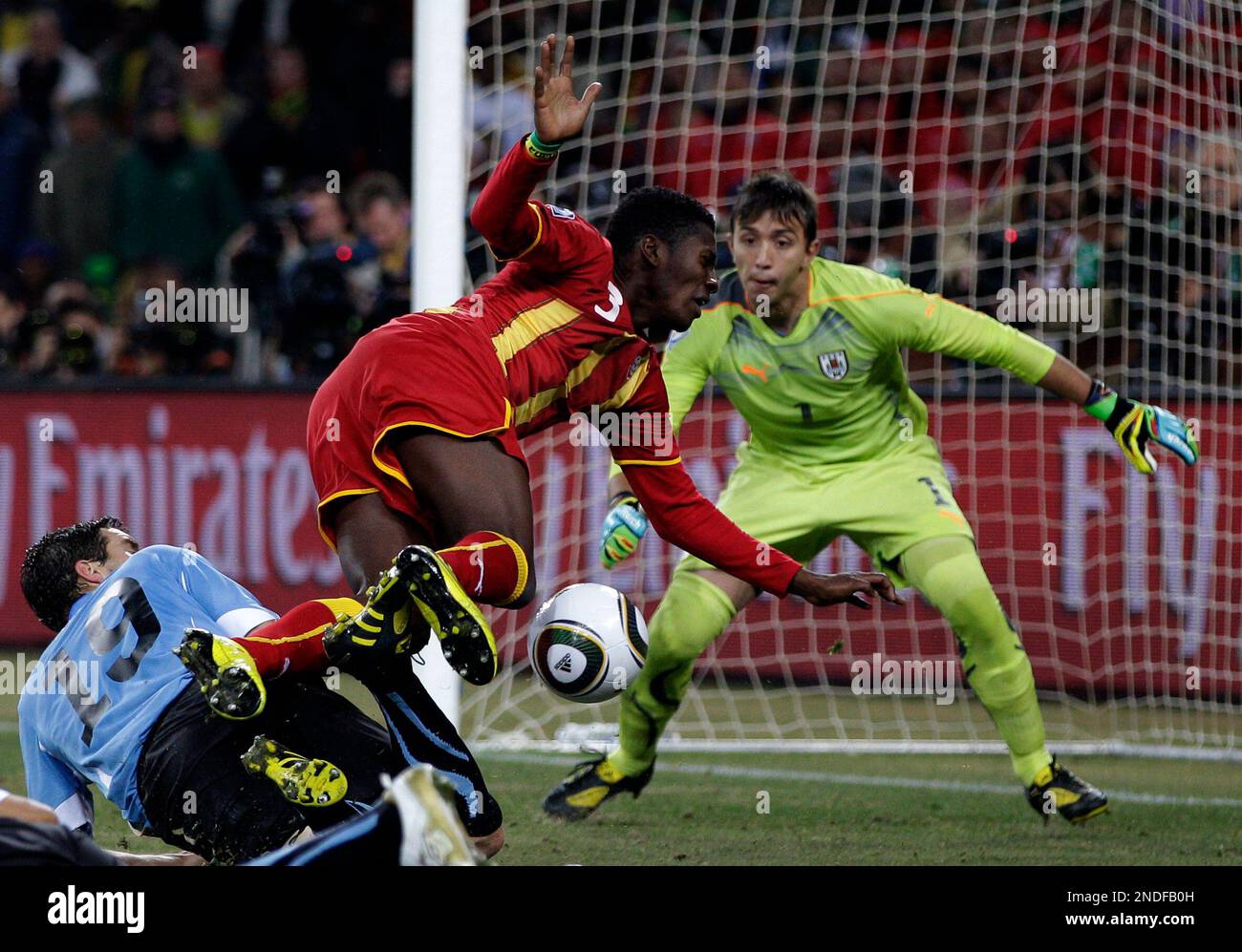 Ghana's Asamoah Gyan, center, is tackled by Uruguay's Andres Scotti ...