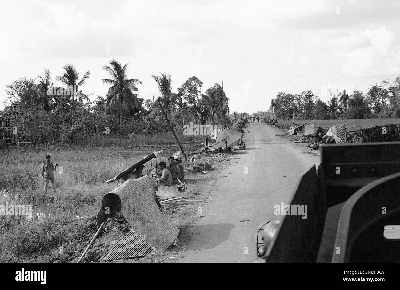 Cambodian soldiers and their families sit in makeshift housing which ...