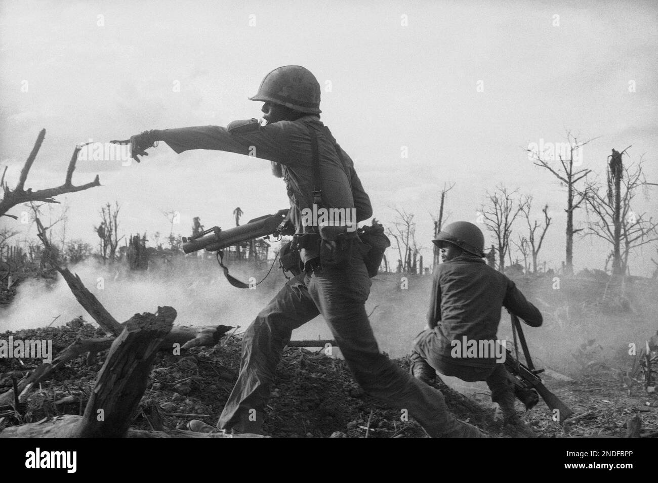 Cambodian soldier, armed with grenade launcher, gives orders to his men ...