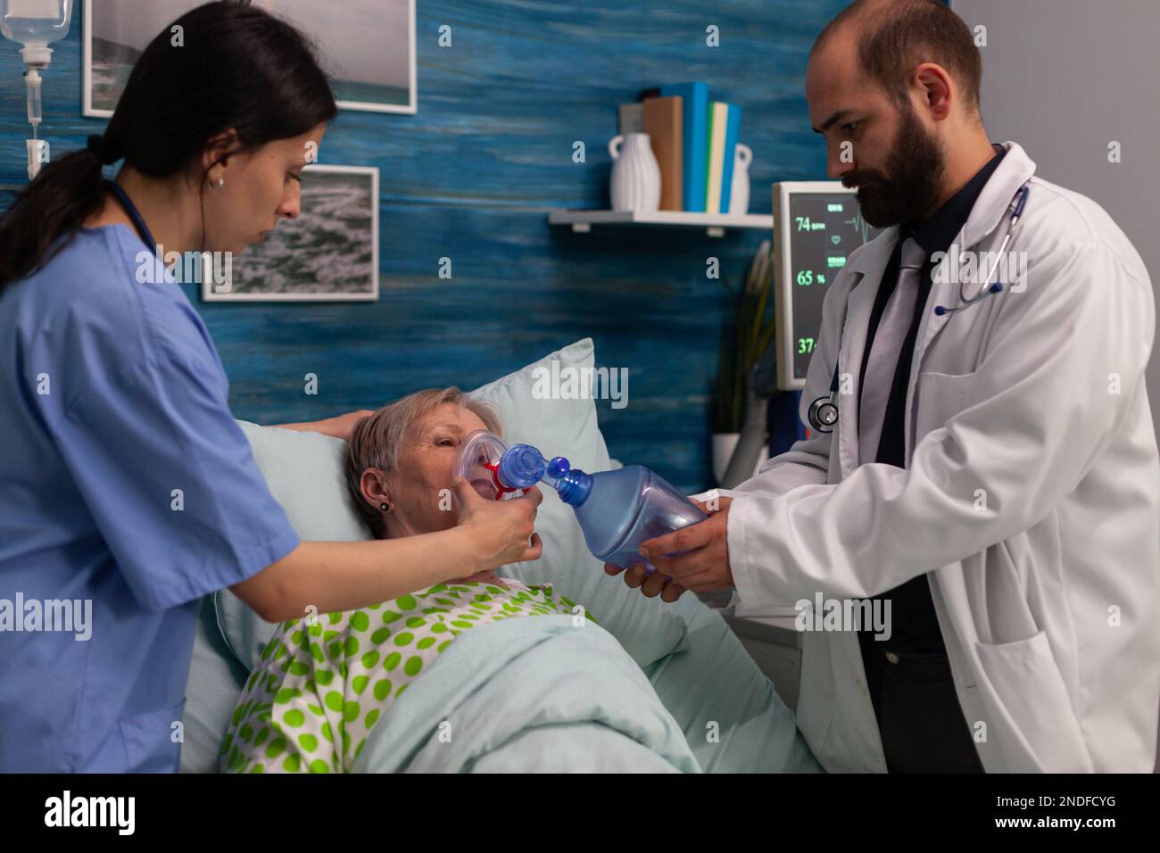 Doctor helping woman with lung disease to help her breathe with manual respirator. Female nurse ...