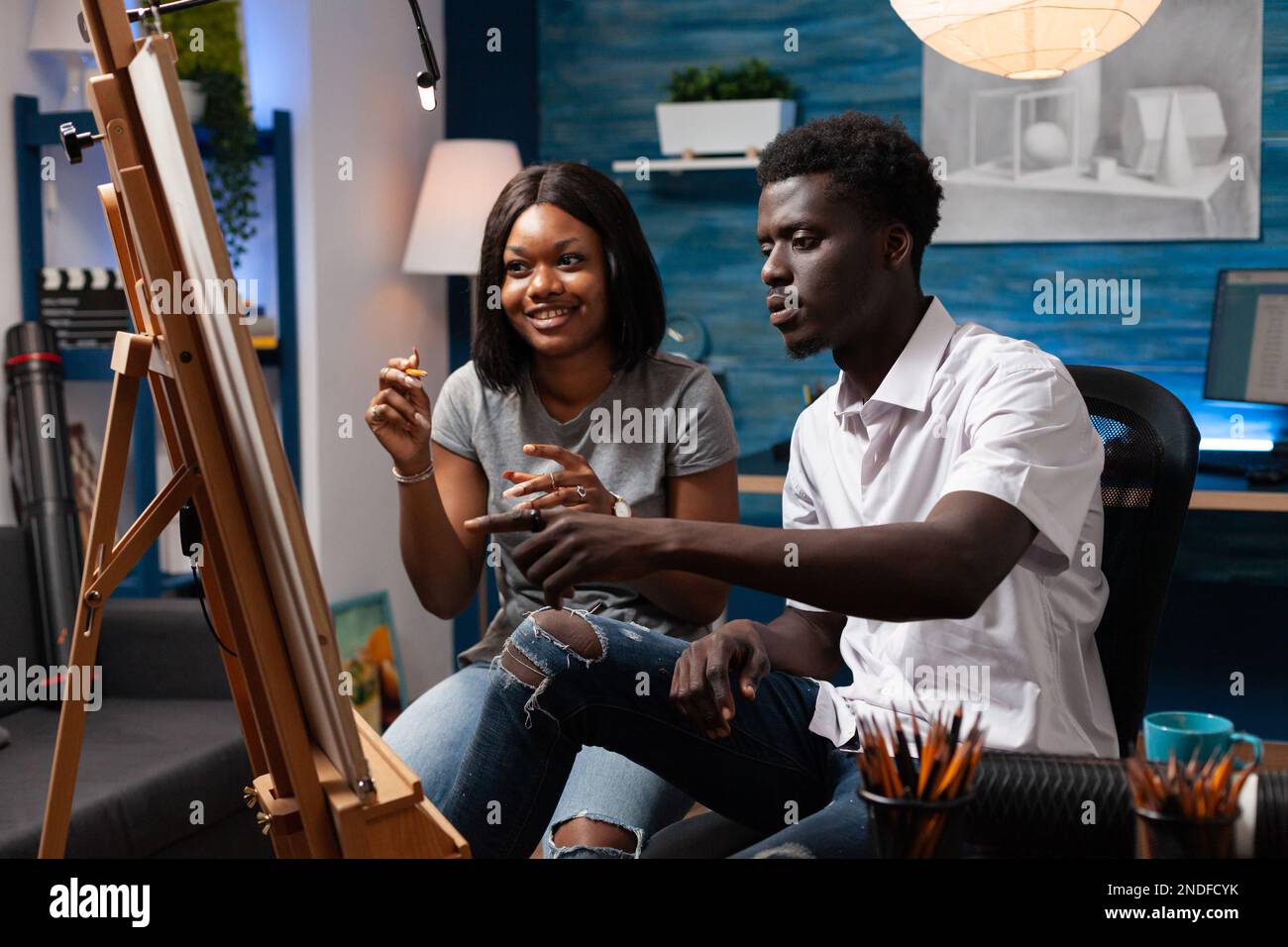 Art teacher showing new drawing technique to african american female ...