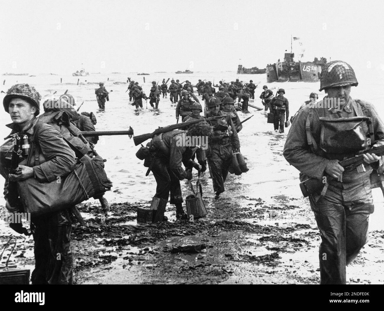 American troops loaded with equipment wade ashore and make for their ...