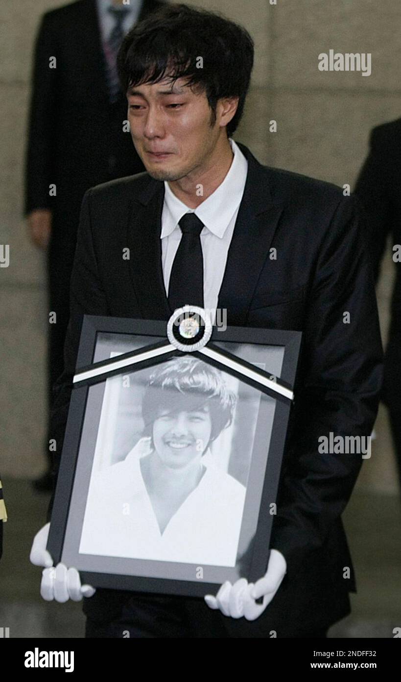 South Korean actor So Ji-sub carries a portrait of deceased South ...