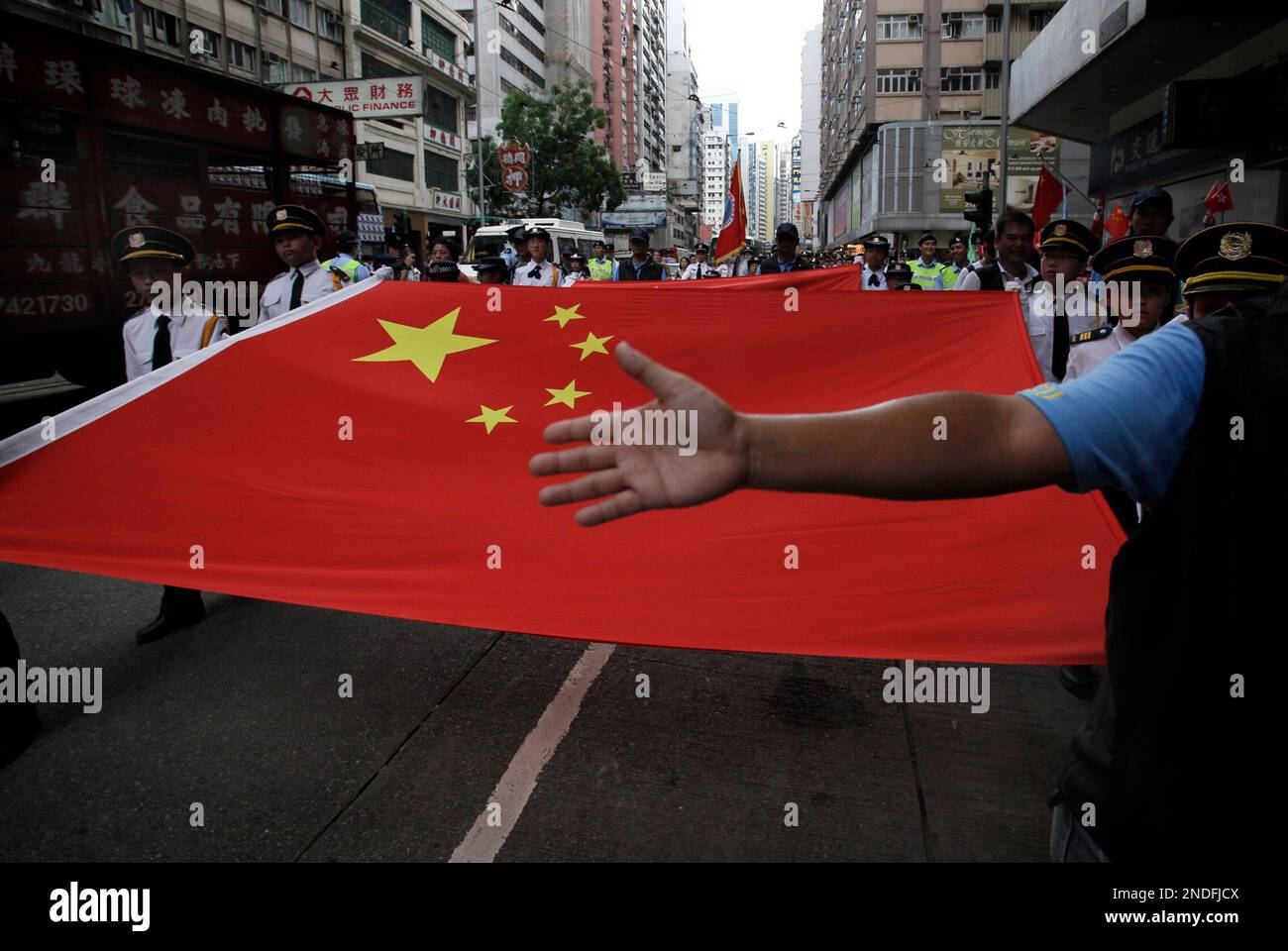 Participants carry Chinese national flags during a parade in a downtown ...