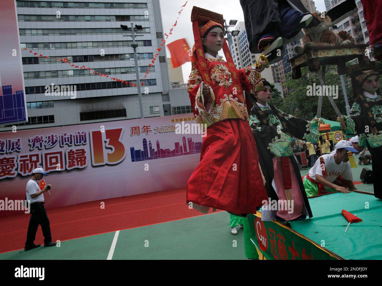 Participants dressed as Chinese opera performers carry Chinese national ...