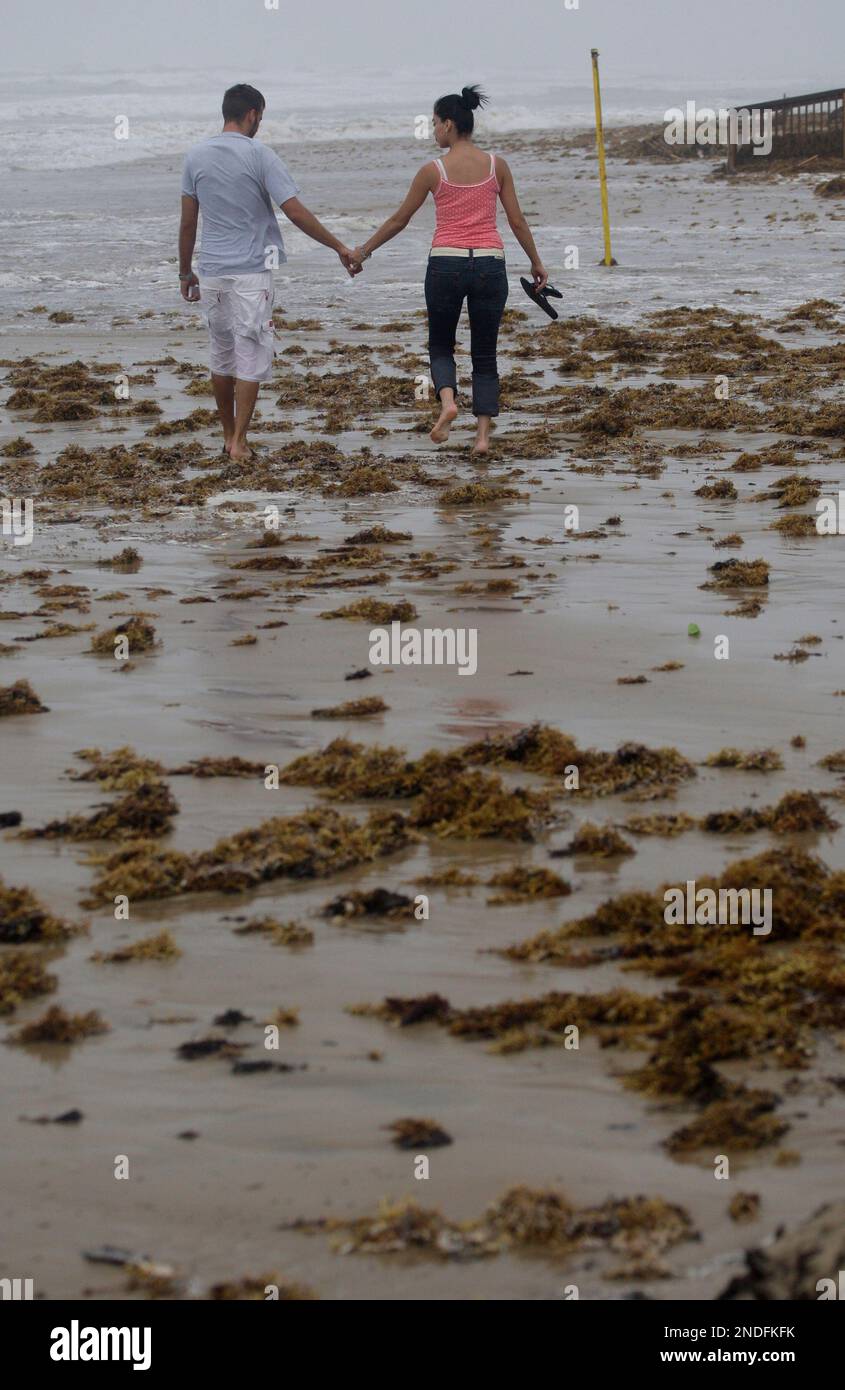 Sam Bearden, left, and Melisa Escamilla. right, walk over debris as ...