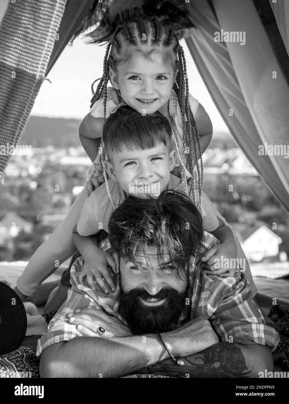 Young handsome father spend his free time with kids. Children put their ...