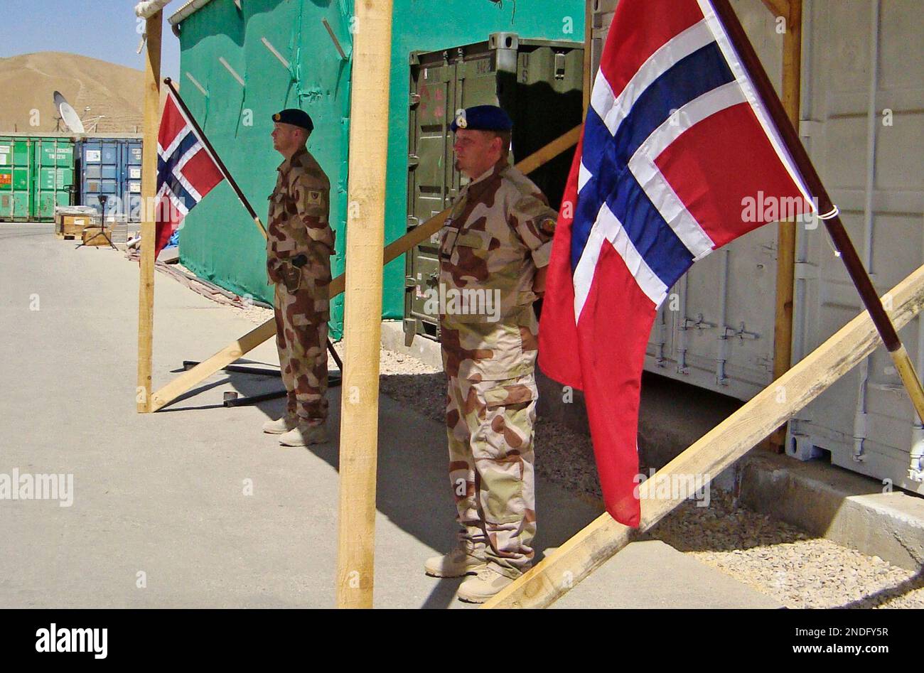 Norwegian soldiers stand in attention in front of containers with the ...