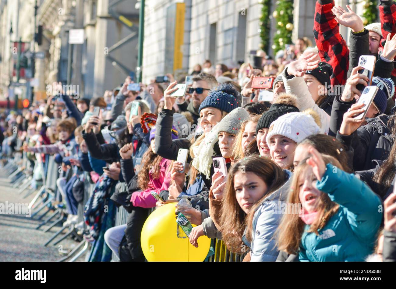 A crowd of people enjoying the Macy's Thanksgiving day parade along ...