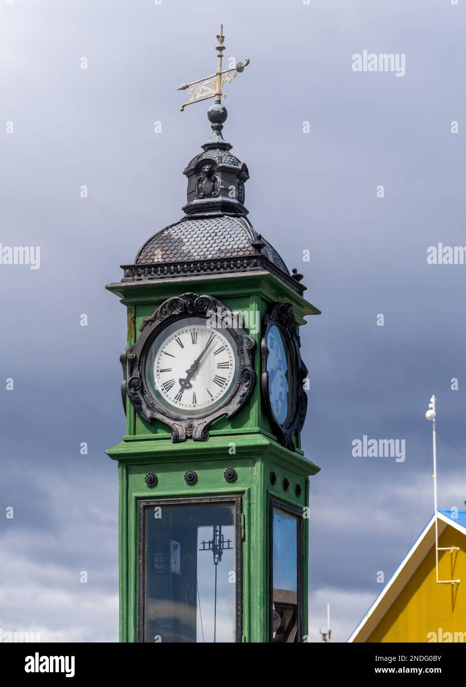 Green antique clock tower and meteorology station by the port and ...