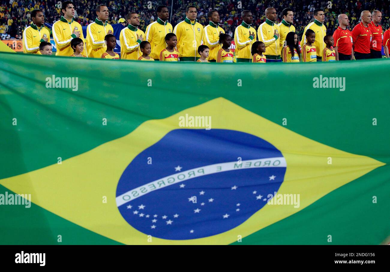 Brazil team line up behind their national flag as they listen to the ...