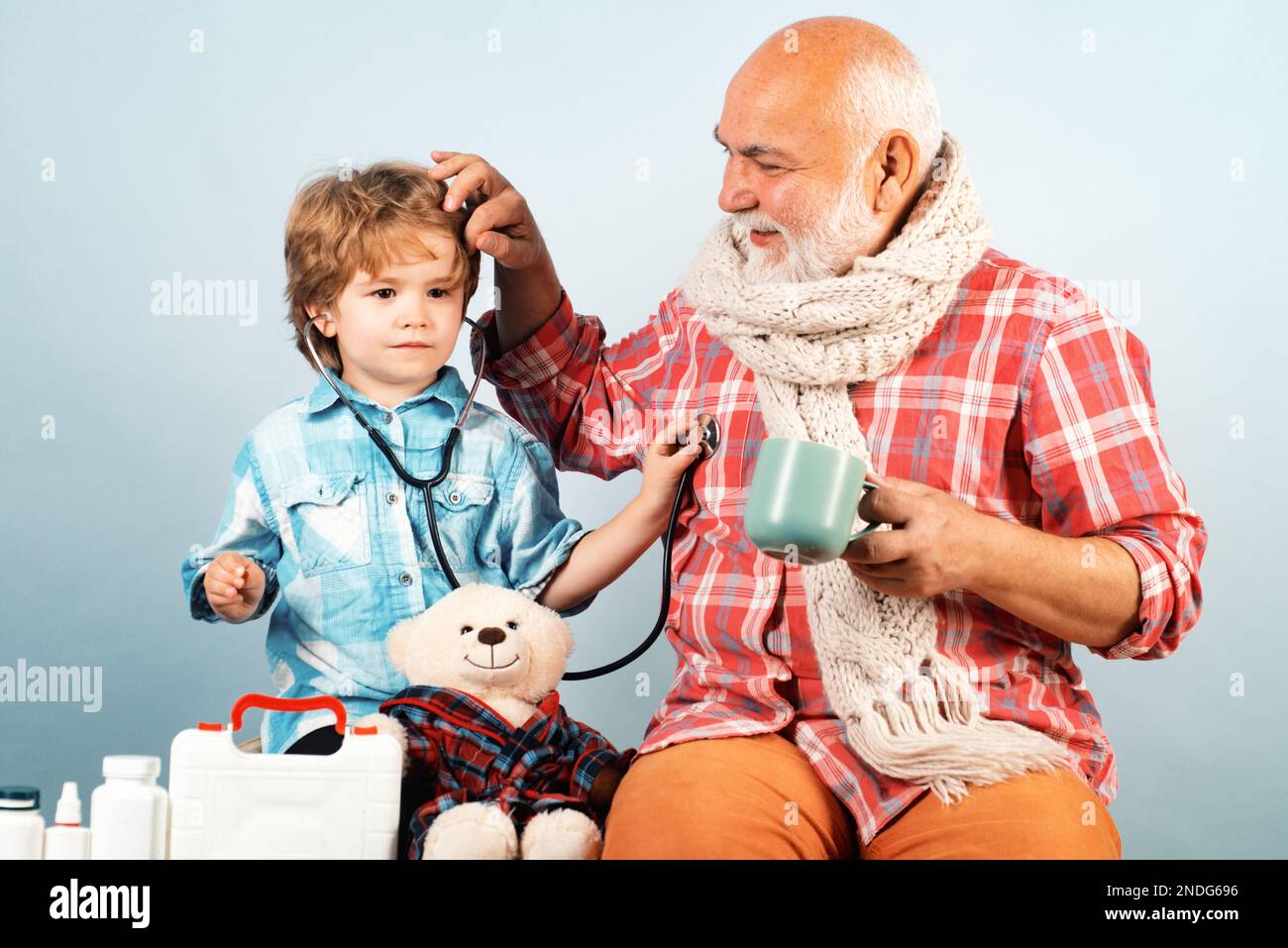 Little doctor giving grandfather medicament. Little doctor using a ...