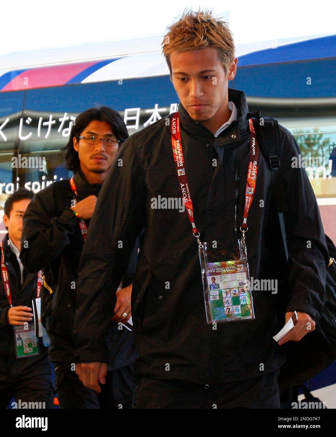 Japan's Keisuke Honda, front, and Yuji Nakazawa arrive at the airport for the departure, in ...