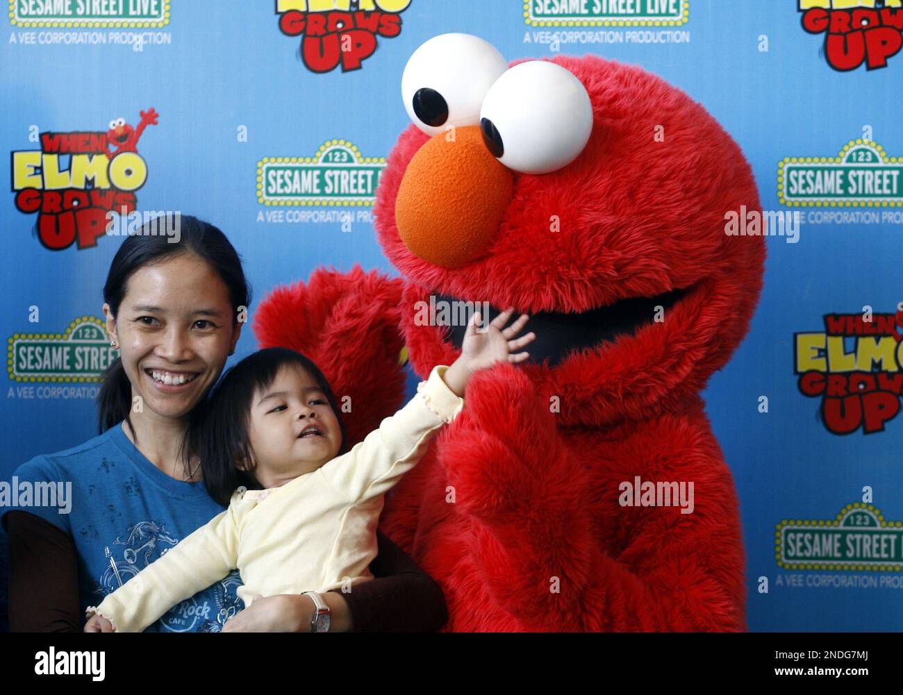 A girl gestures to Sesame Street character Elmo at a shopping center in ...