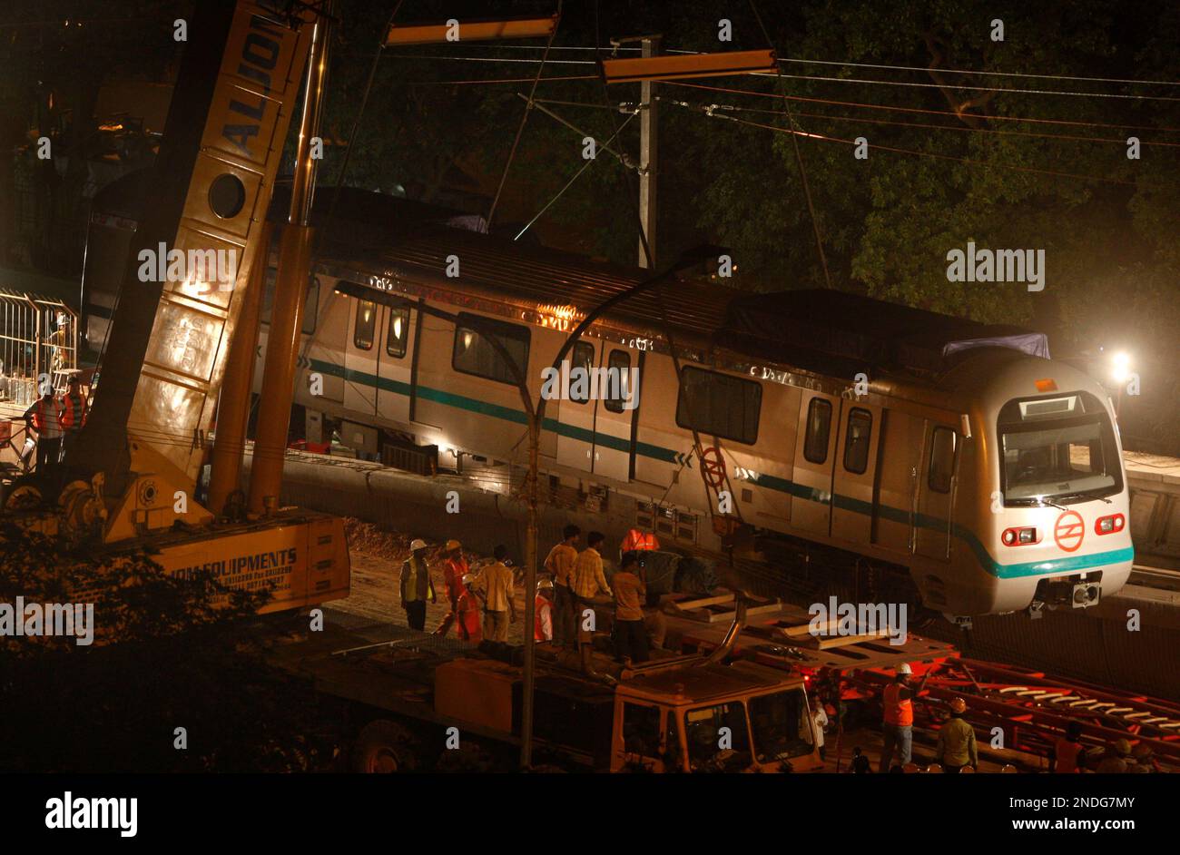 A Delhi Metro rail coach is lifted to the track for trial runs on a new ...