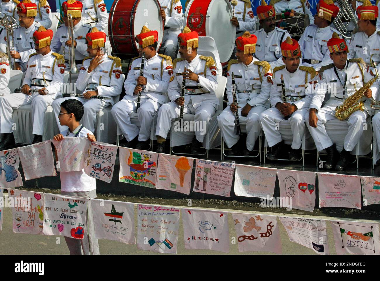 An Indian child holds a string of cards with peace messages as band ...