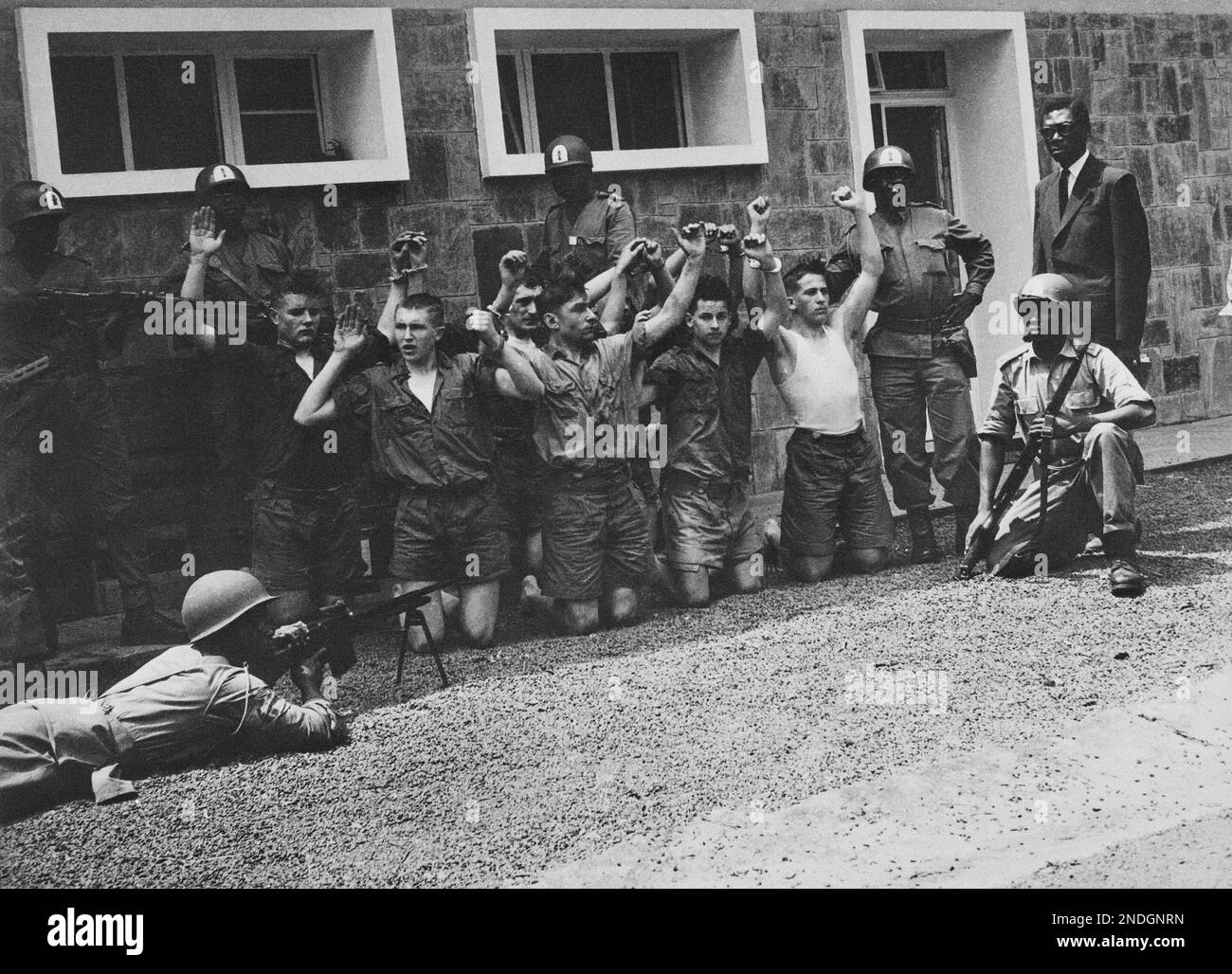 Eight Belgian soldiers, kneeling with manacled hands above their heads ...