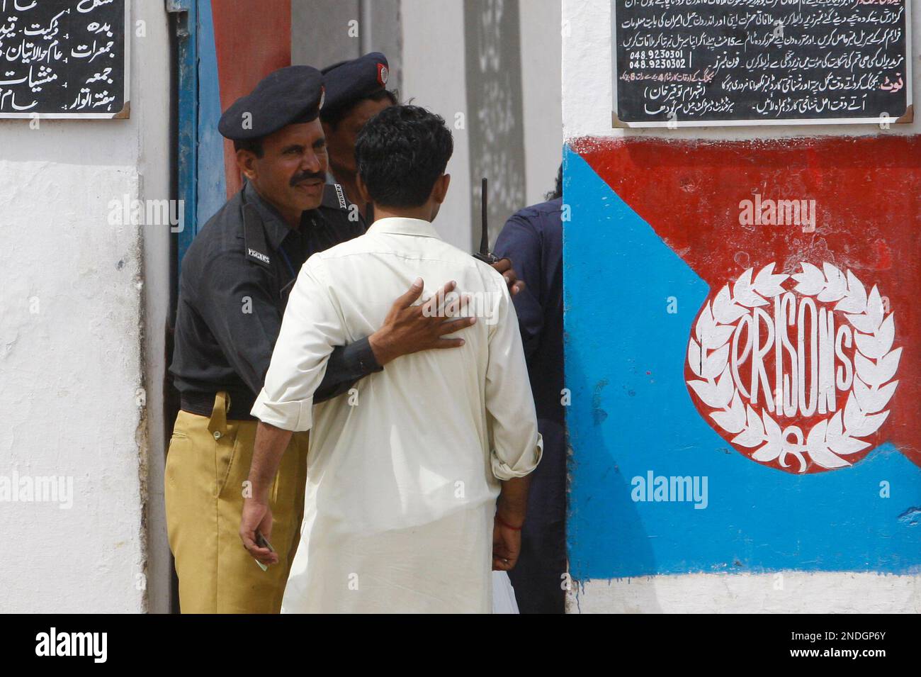 A Pakistani police officer frisks a man at the entrance of the district ...