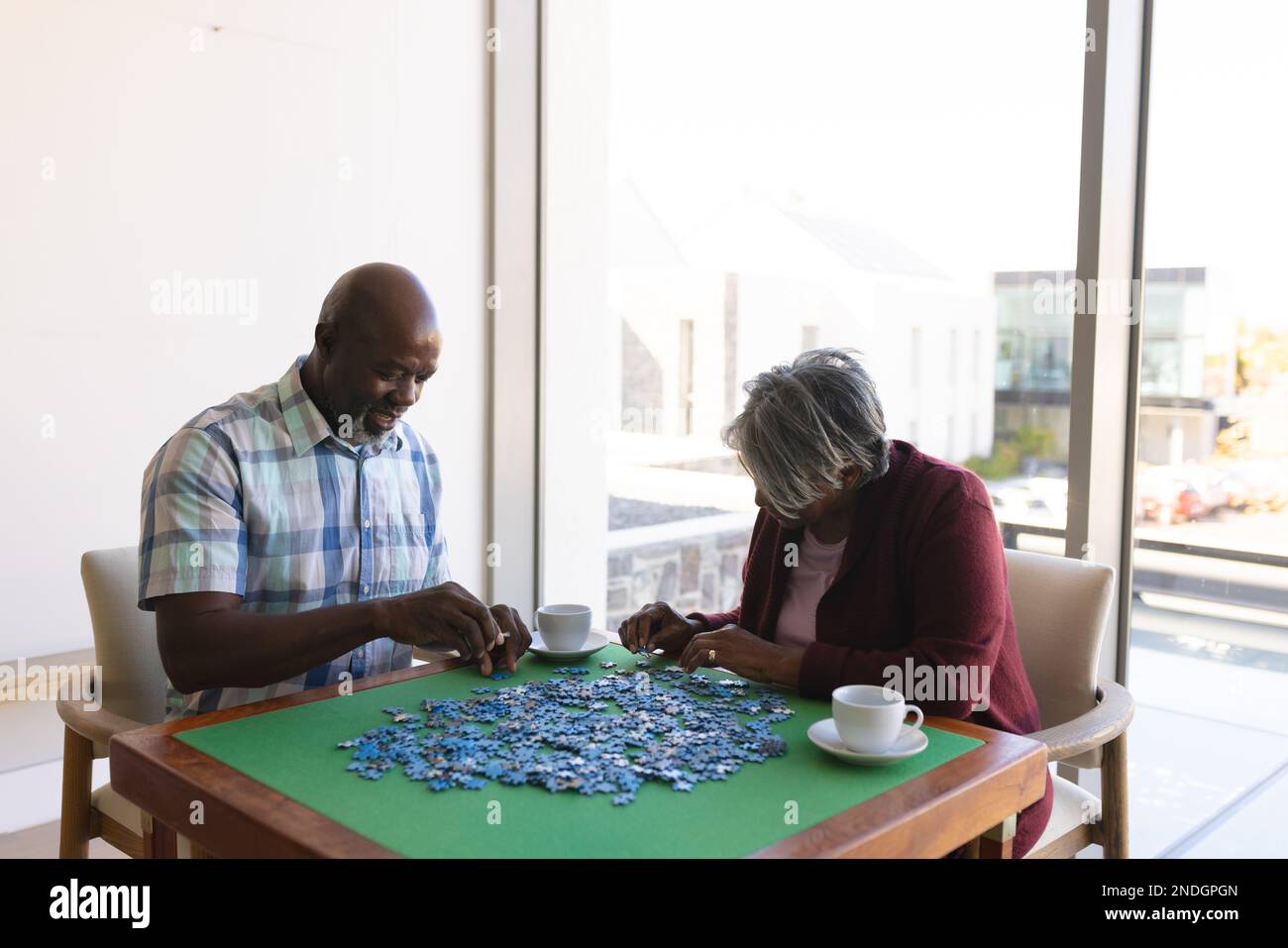 African american senior couple solving jigsaw puzzle at home ...