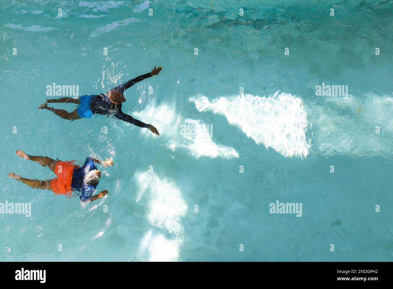 Aerial view of african american senior couple swimming together in the ...