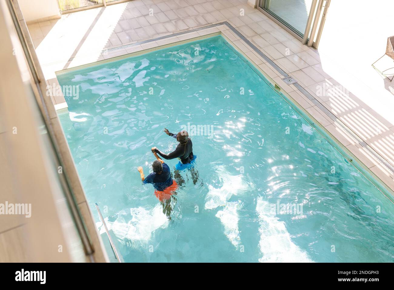 Aerial view of african american senior couple swimming together in the ...