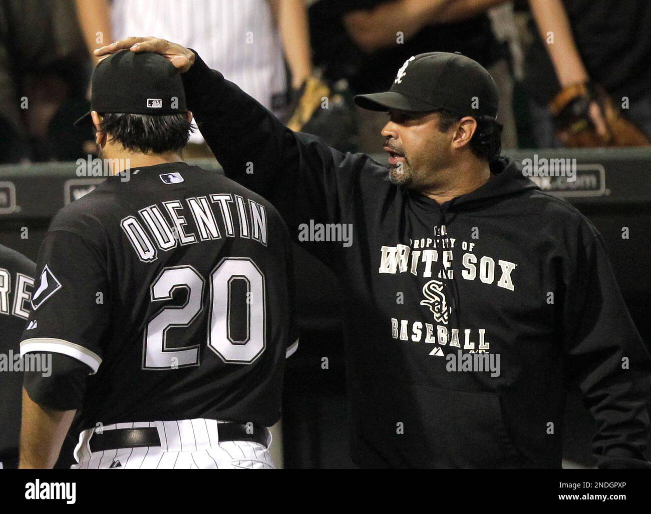 Chicago White Sox manager Ozzie Guillen, right, pats Carlos Quentin on ...