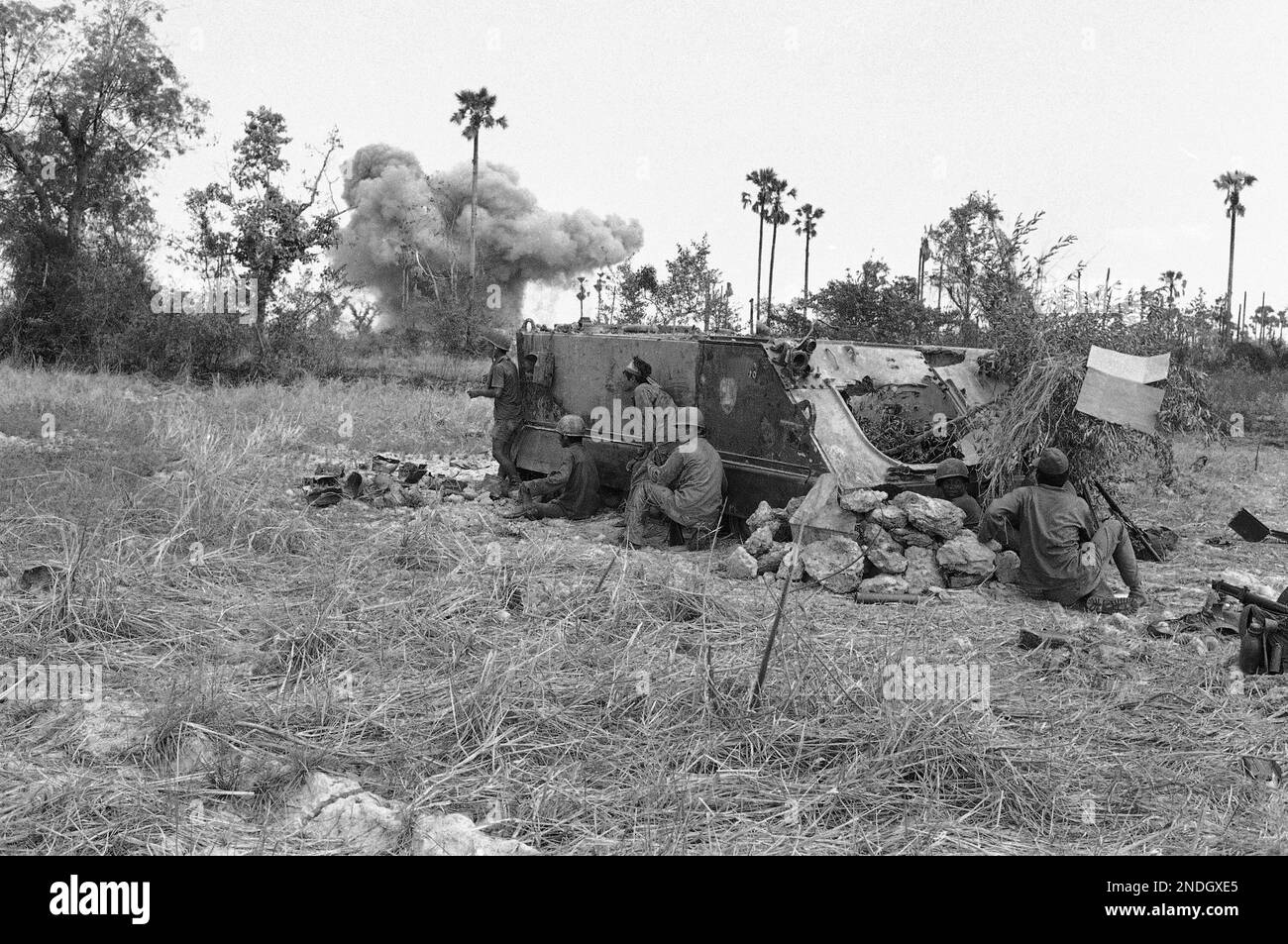 Cambodian army troops crouch behind a kayoed armored personnel carrier ...