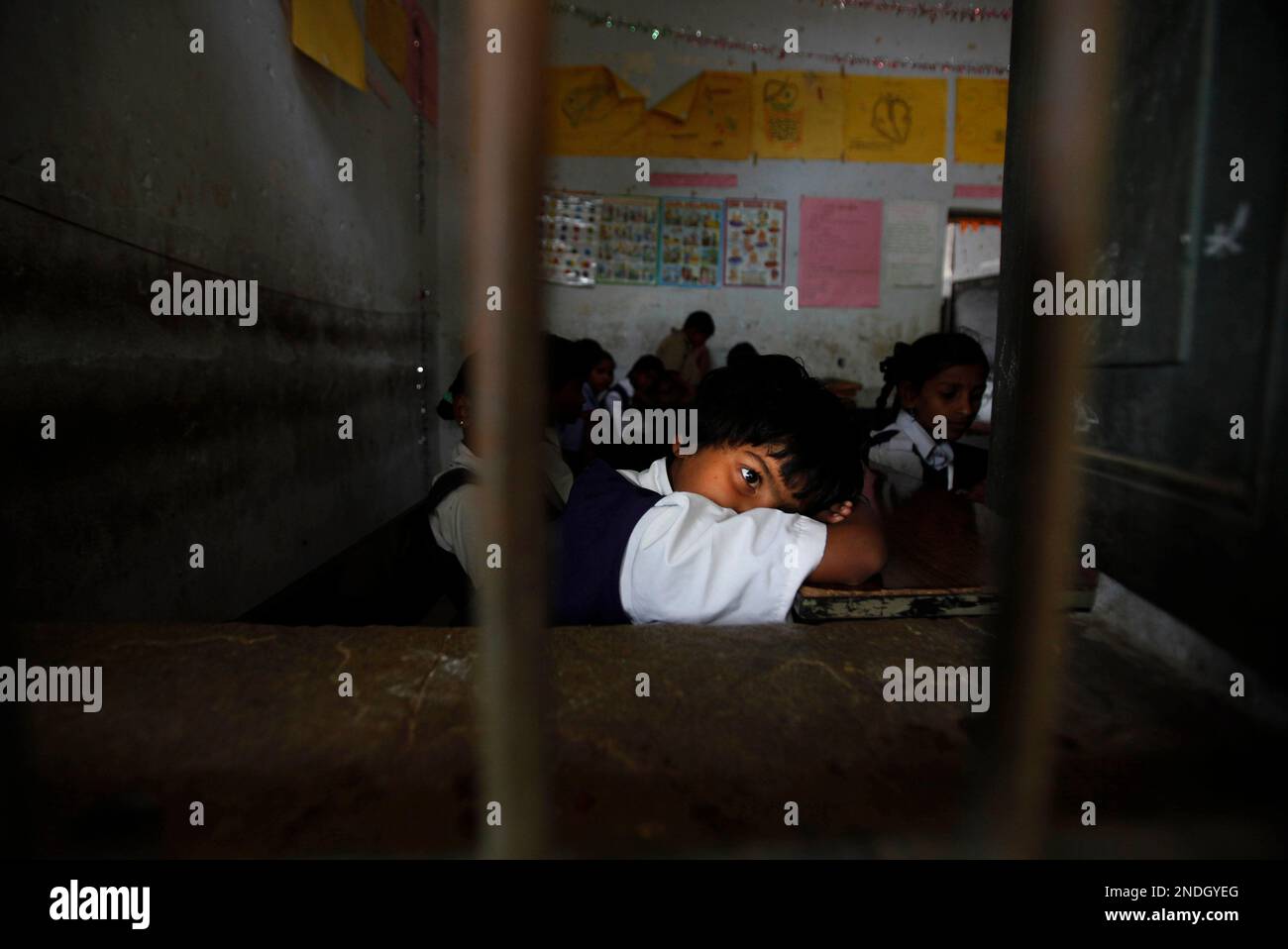 An Indian school child looks on from inside a classroom at a government ...