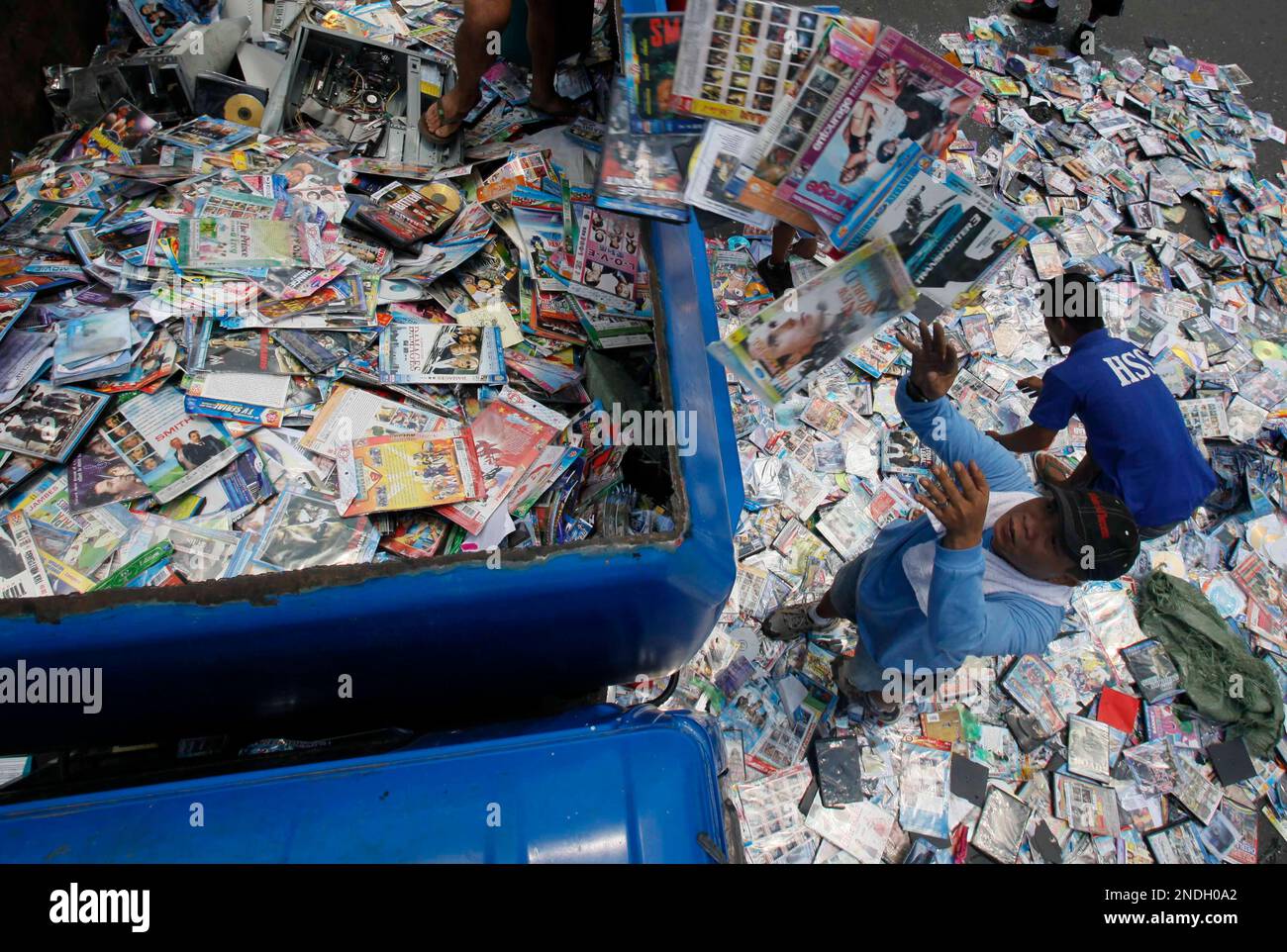 Workers haul away pirated DVDs following a symbolic destruction of ...