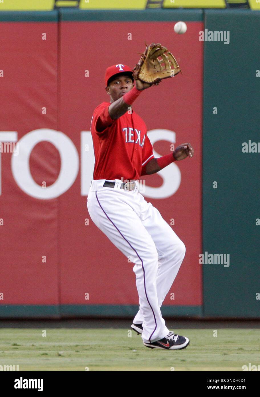 Texas Rangers center fielder Julio Borbon reaches up to grab a fly out ...