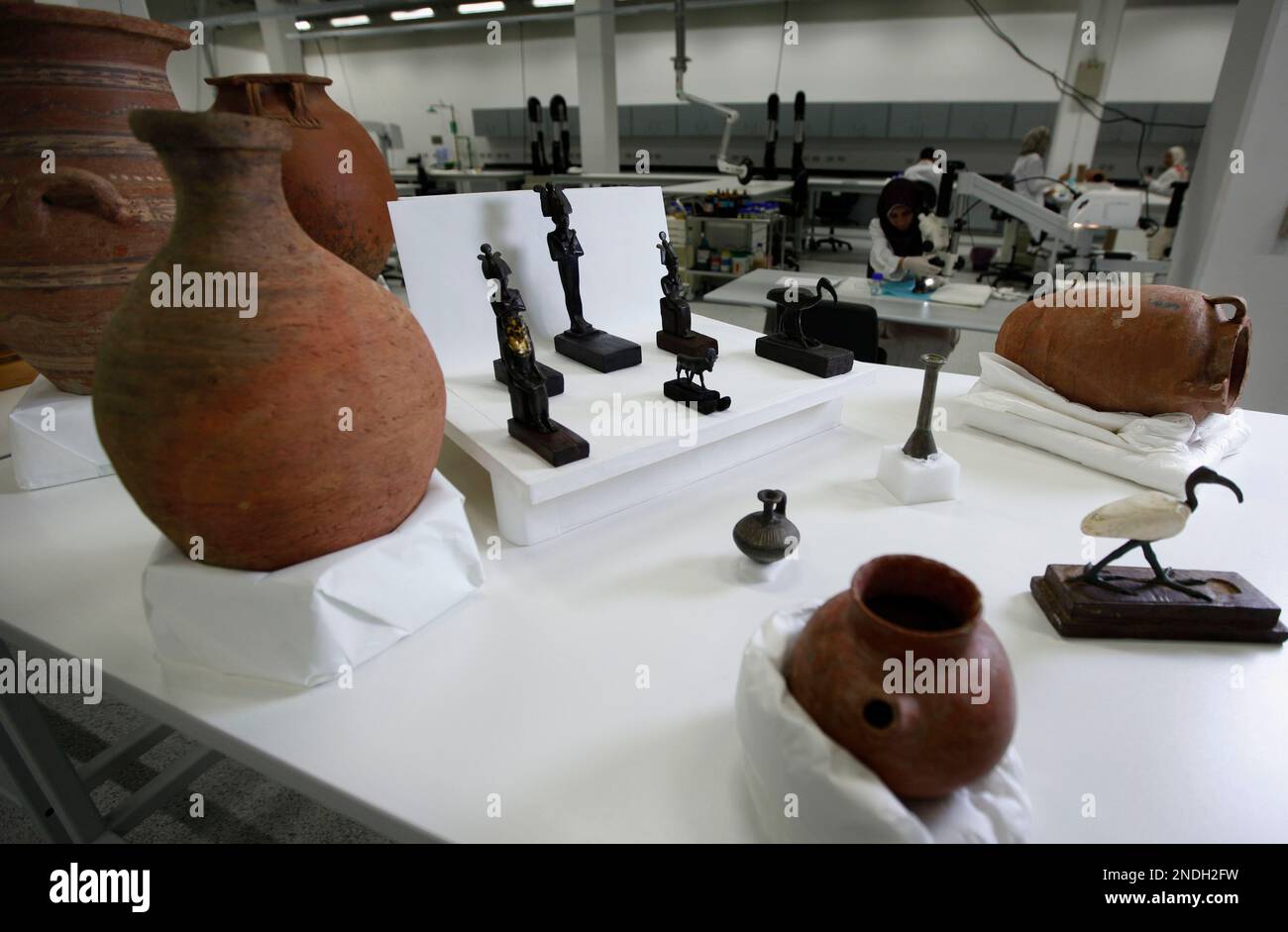 An Egyptian archeological technician works by conservated objects at ...