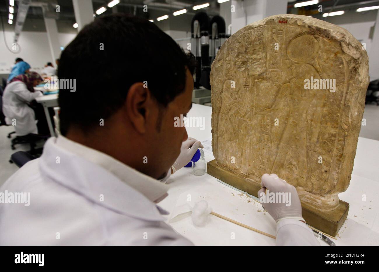 An Egyptian archeological technician works at a pharonic late period ...