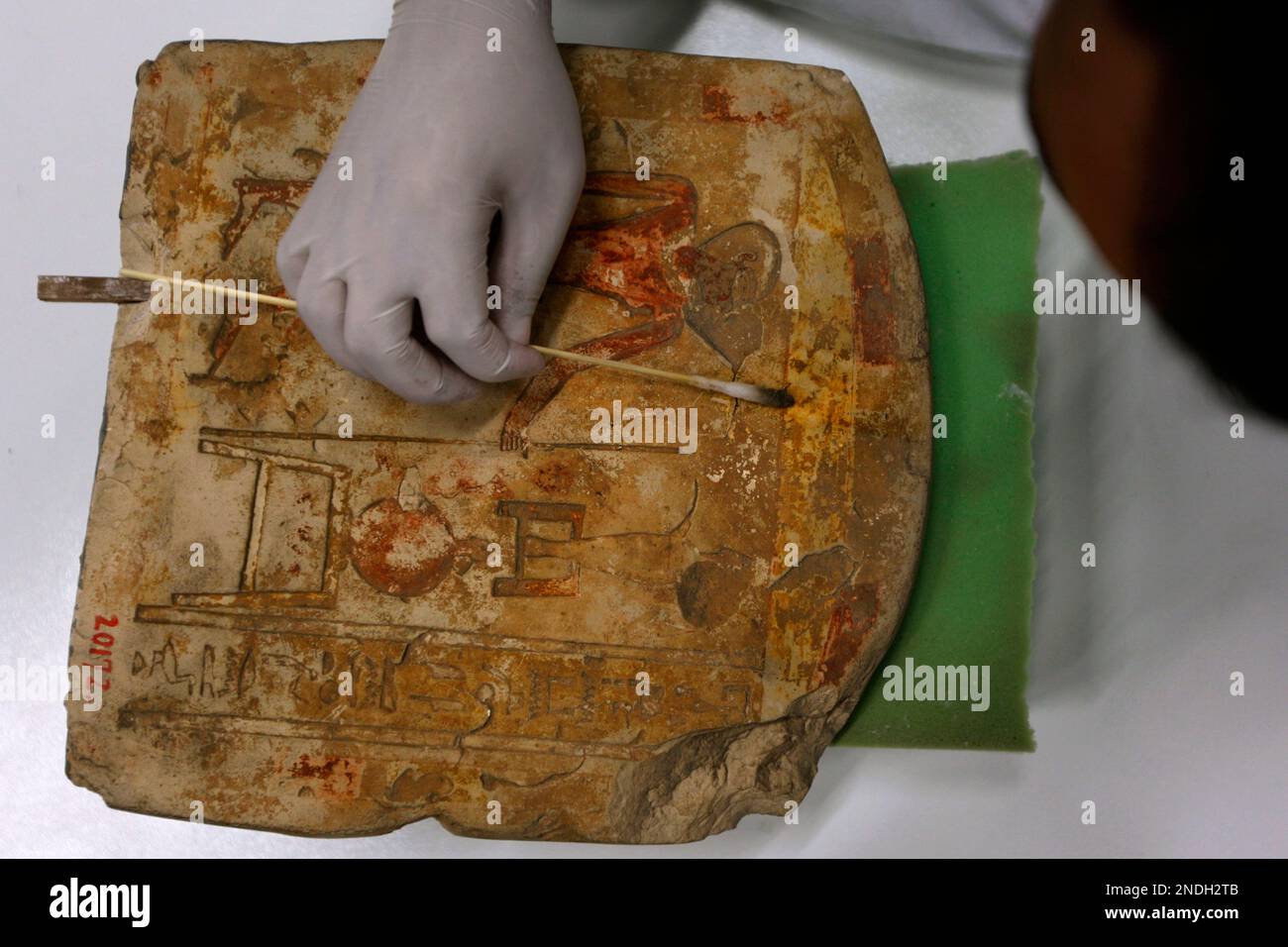 An Egyptian archeological technician works at a pharonic late period ...