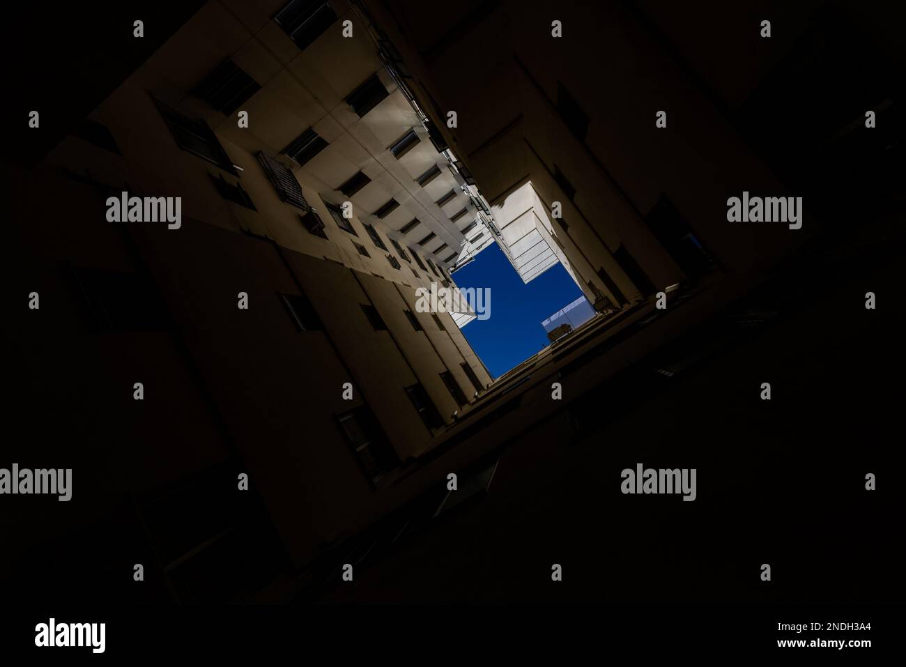 A low angle shot of tall building in shadow with blue sky above Stock ...