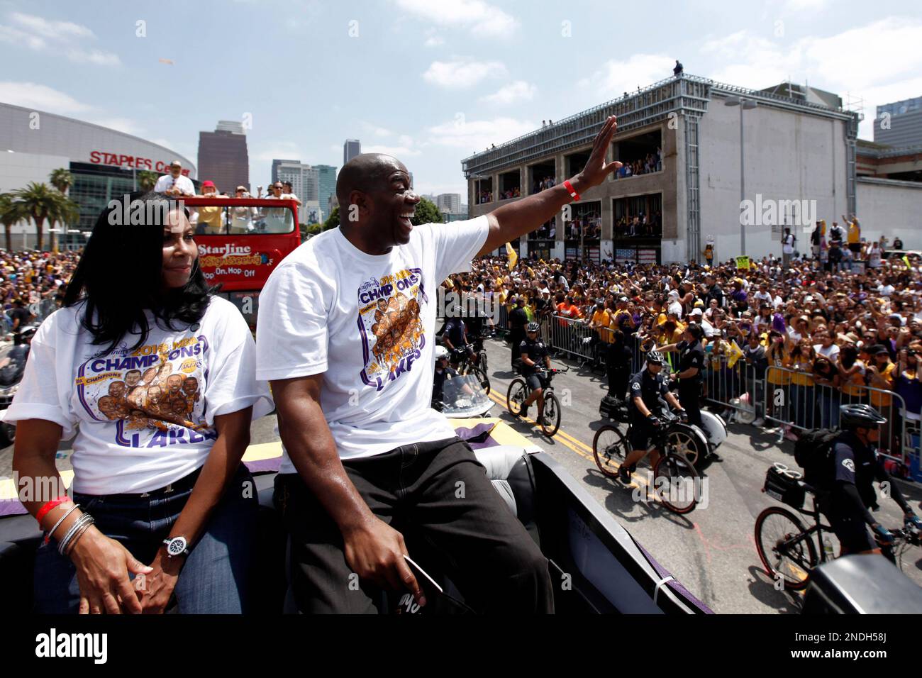 Magic Johnson, right, and his wife, Cookie, wave to the crowd during ...