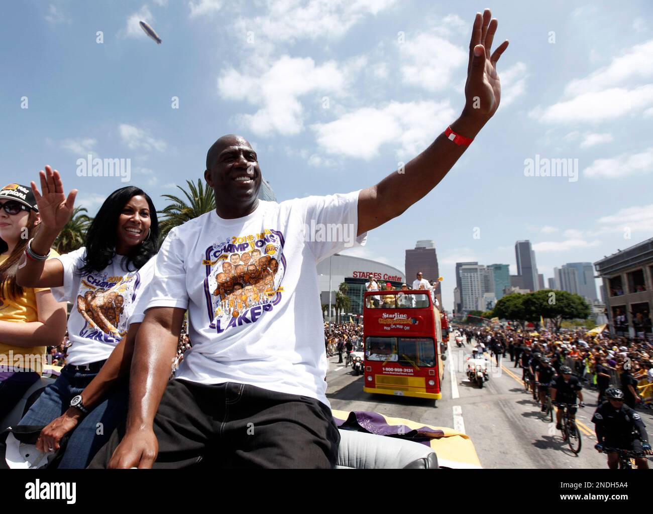 Magic Johnson, right, and his wife, Cookie, wave to the crowd during ...