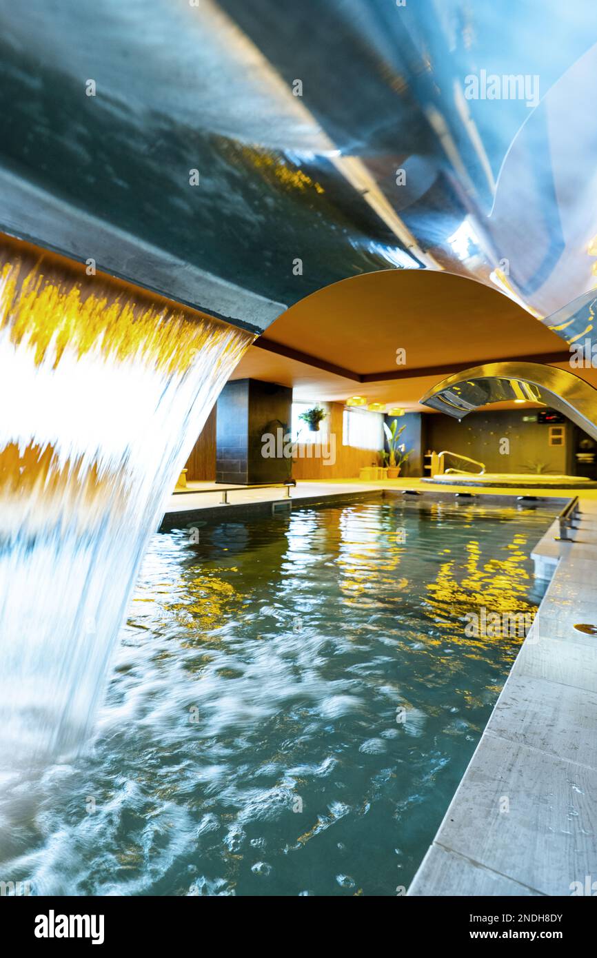 An elongated polished stainless steel spout shooting a stream of water ...