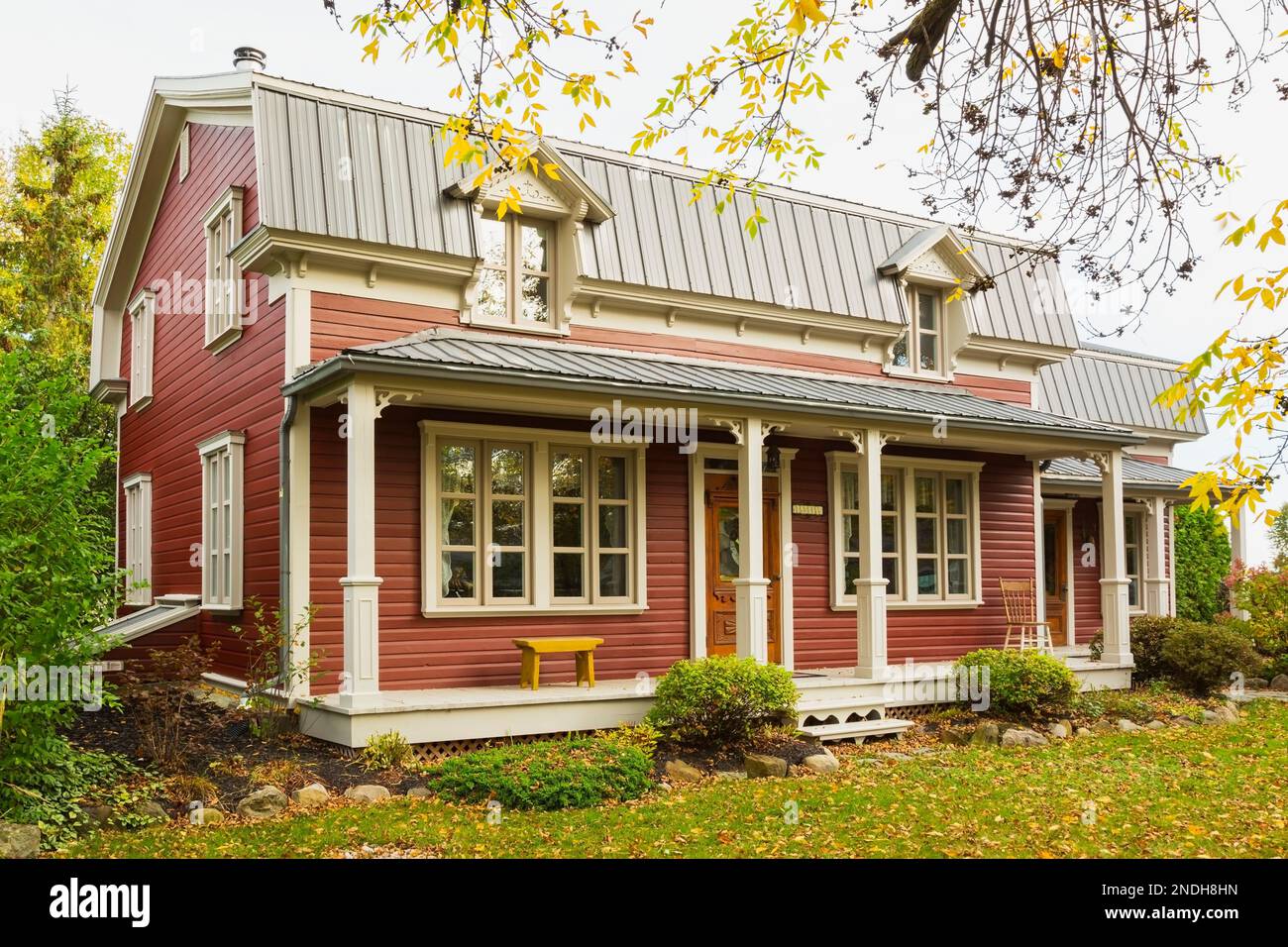 Old 1892 burgundy with white trim pinewood plank house facade with ...