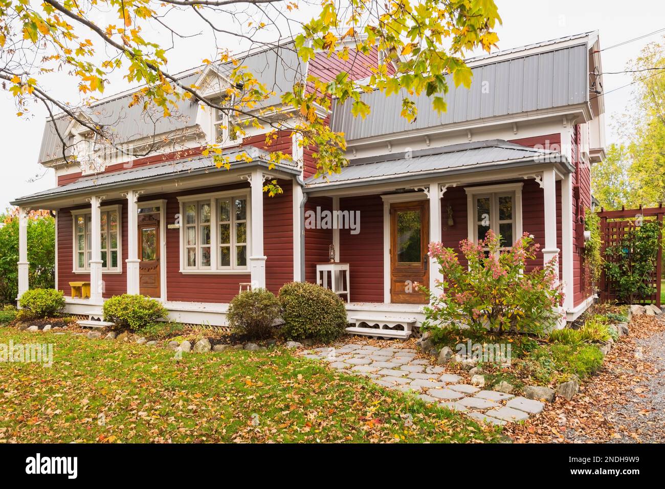 Old 1892 burgundy with white trim pinewood plank house facade with ...