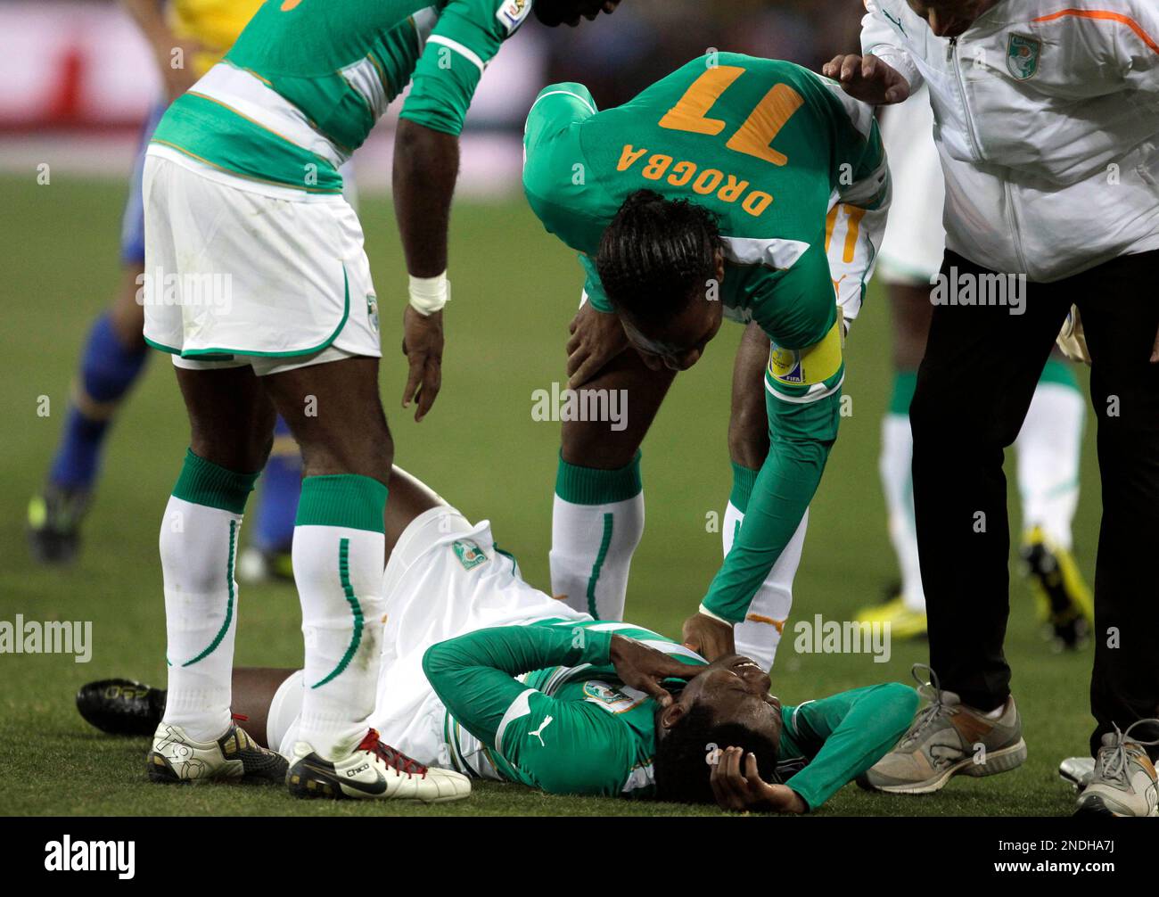 Ivory Coast's Didier Drogba, top, tends to his teammate Abdul Keita ...