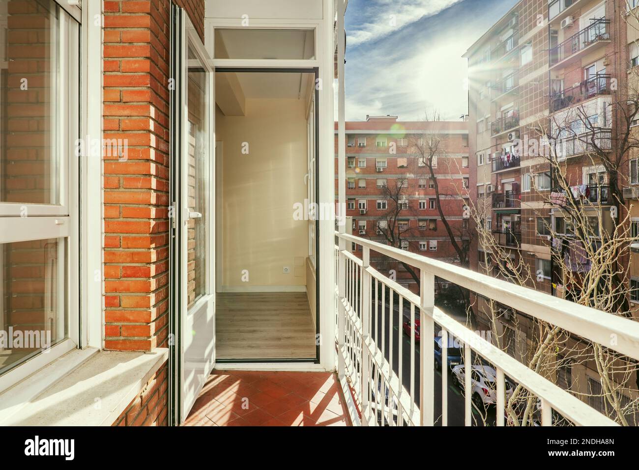 Narrow terrace with white painted metal railing, white aluminum doors ...