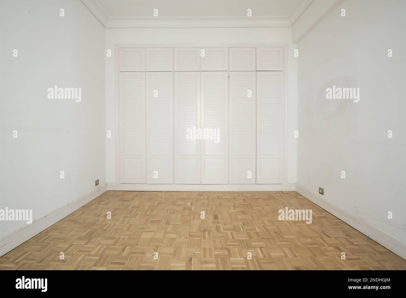 Empty room with one wall covered in white wooden cabinets mezzanine ...